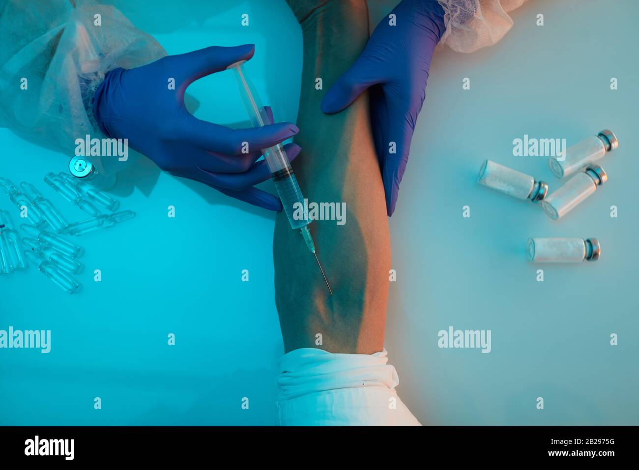 Above view at medic inserting syringe into vein on male arm while ...