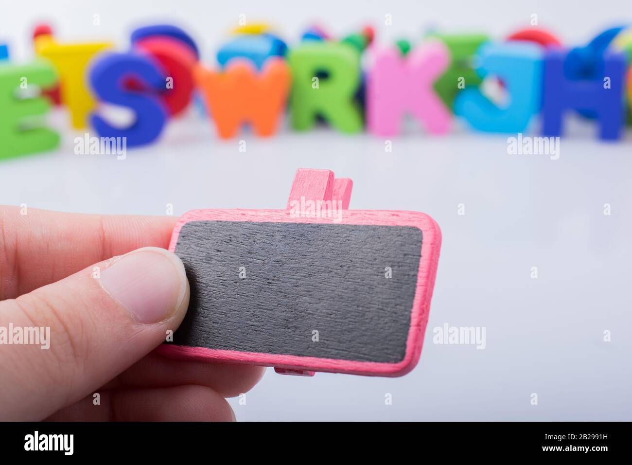 Hand holding a mini size notice board made of wood Stock Photo - Alamy