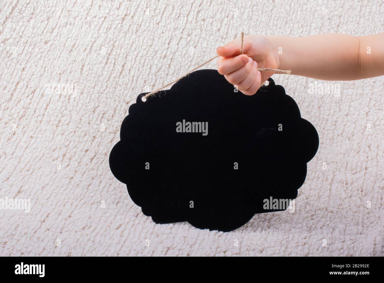 Black speech bubble shaped notice board in hand on white background ...