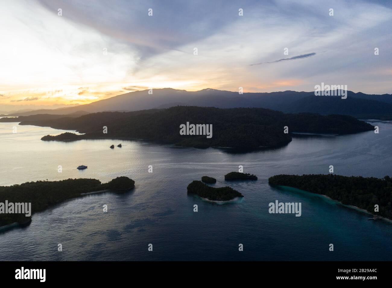 A peaceful sunrise illuminates the remote, tropical islands scattered ...
