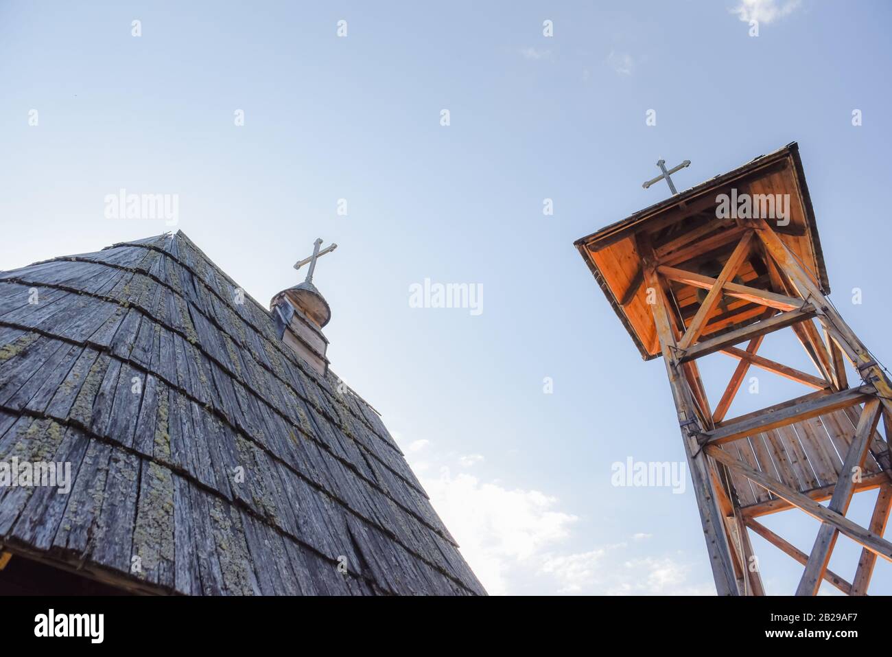 Wider image of a wooden hut roof built from hay with a cross on top as ...