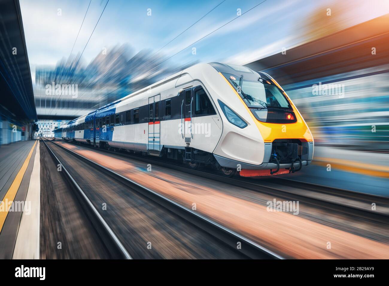 High speed train in motion on the railway station at sunset Stock Photo ...