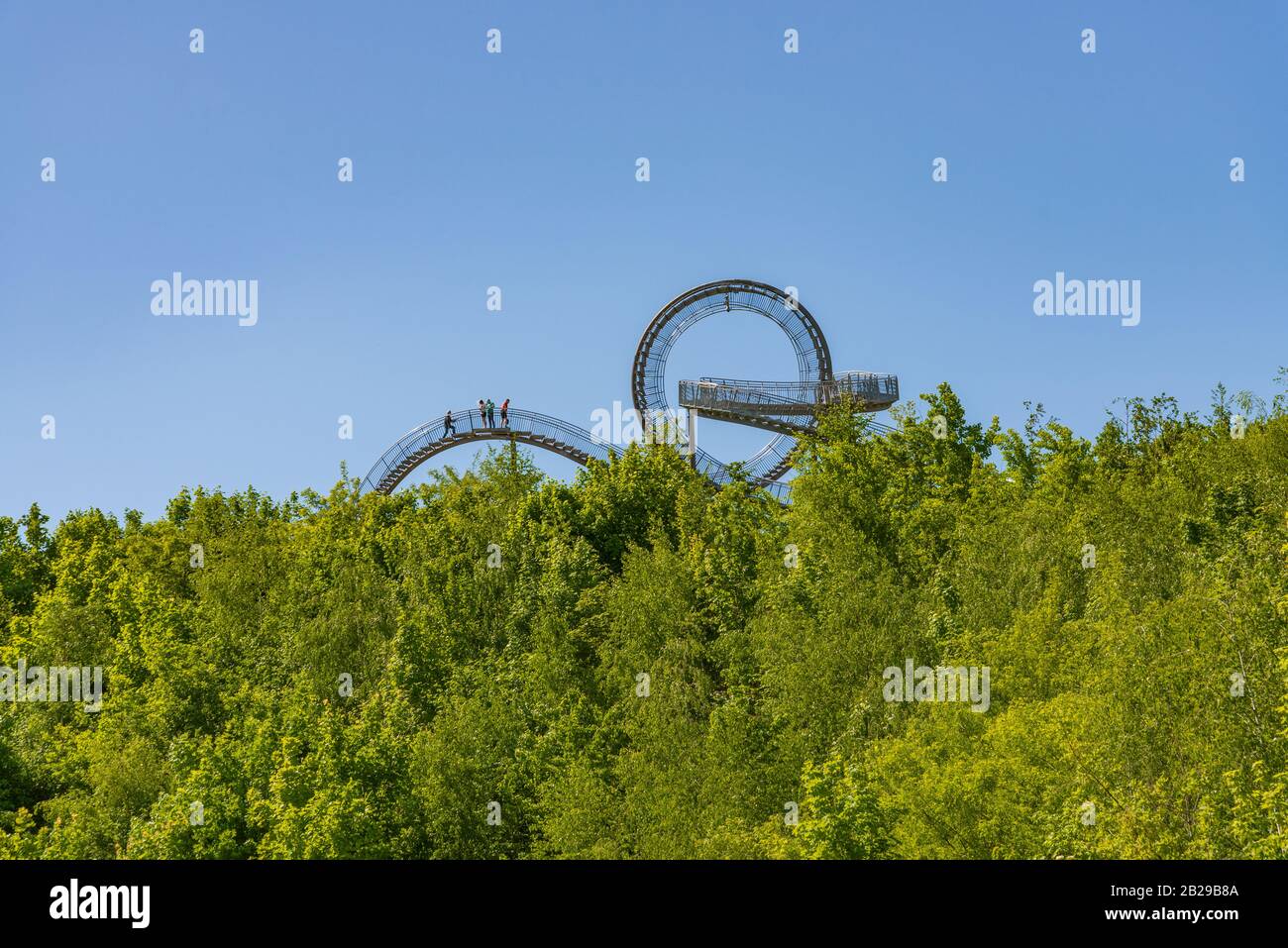 Sunny of people run, walk and step up at loop spiral steel sculpture ...