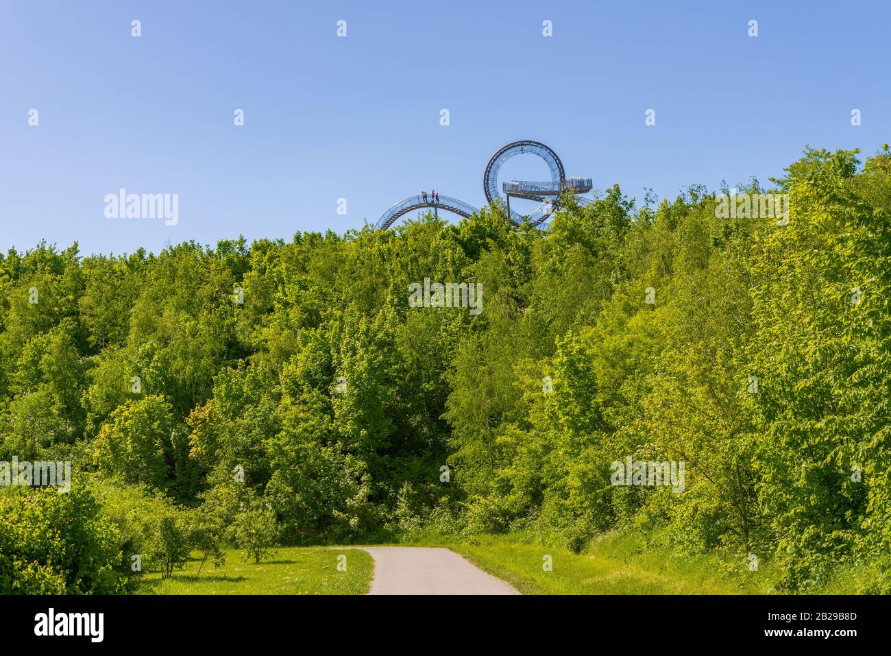 Sunny of people run, walk and step up at loop spiral steel sculpture ...