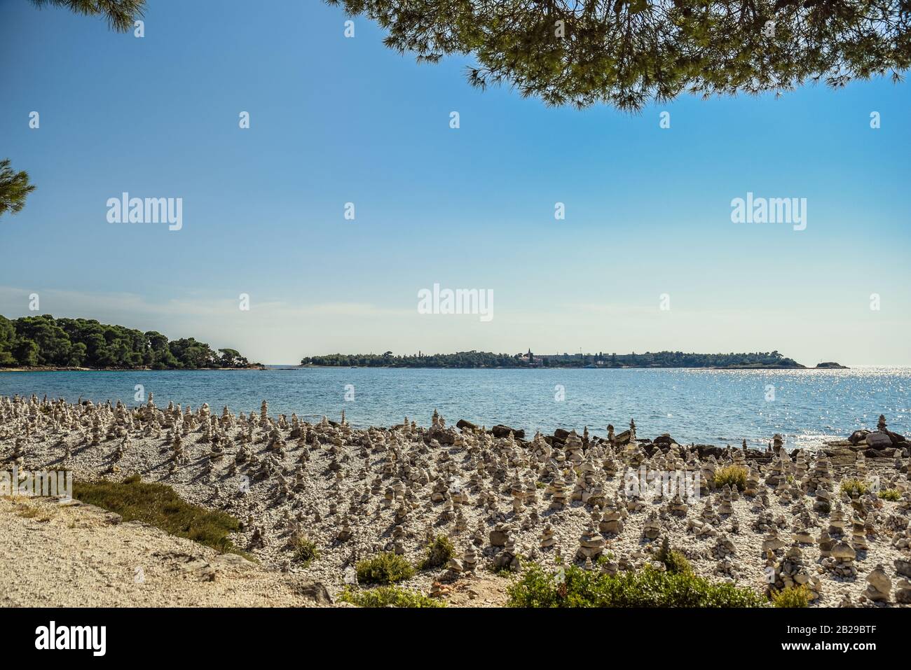 Rovinj beach covered with stacked stones creating one of the most ...