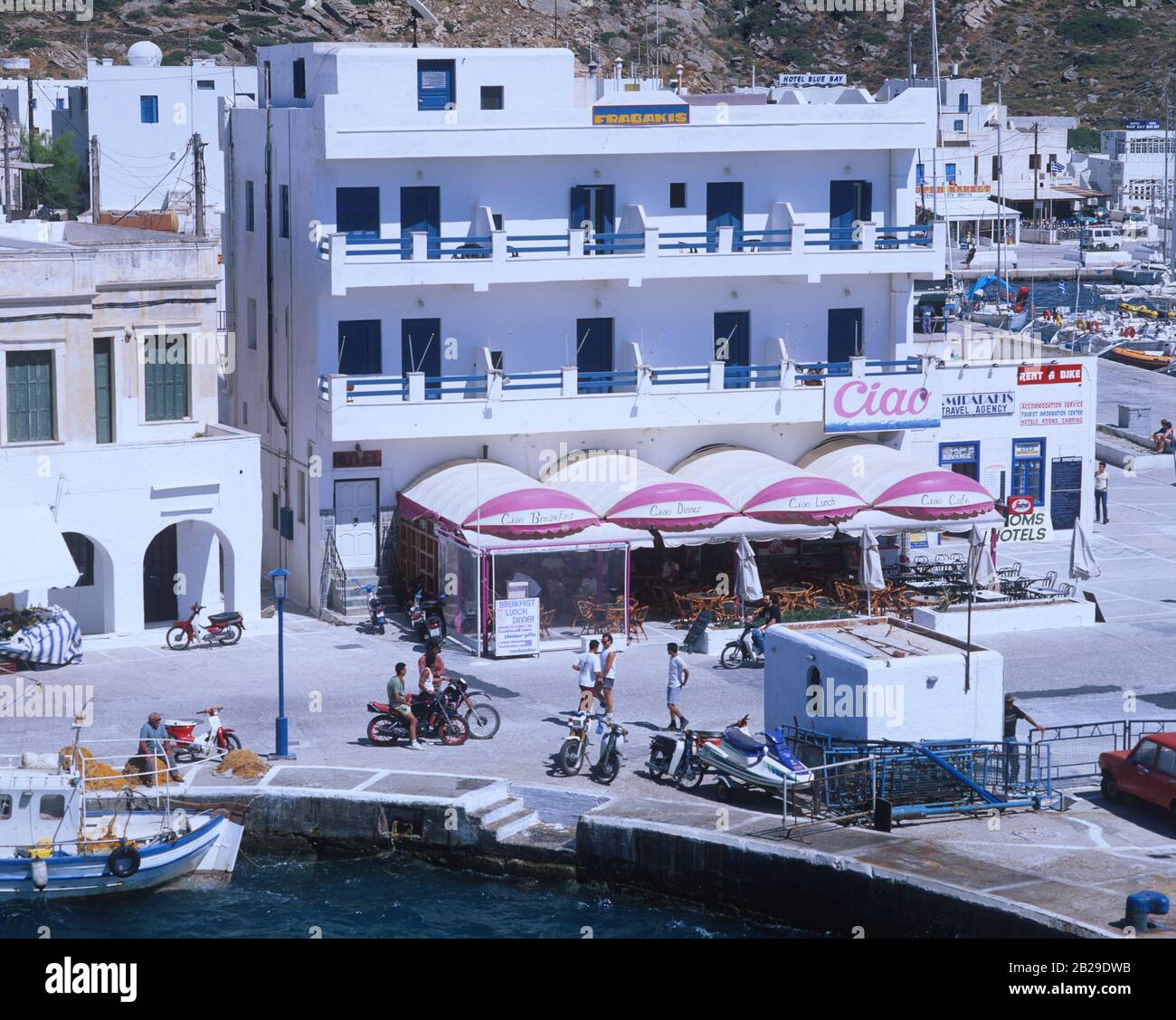 IOS Greek Island with Marina and tourists riding bikes Stock Photo - Alamy