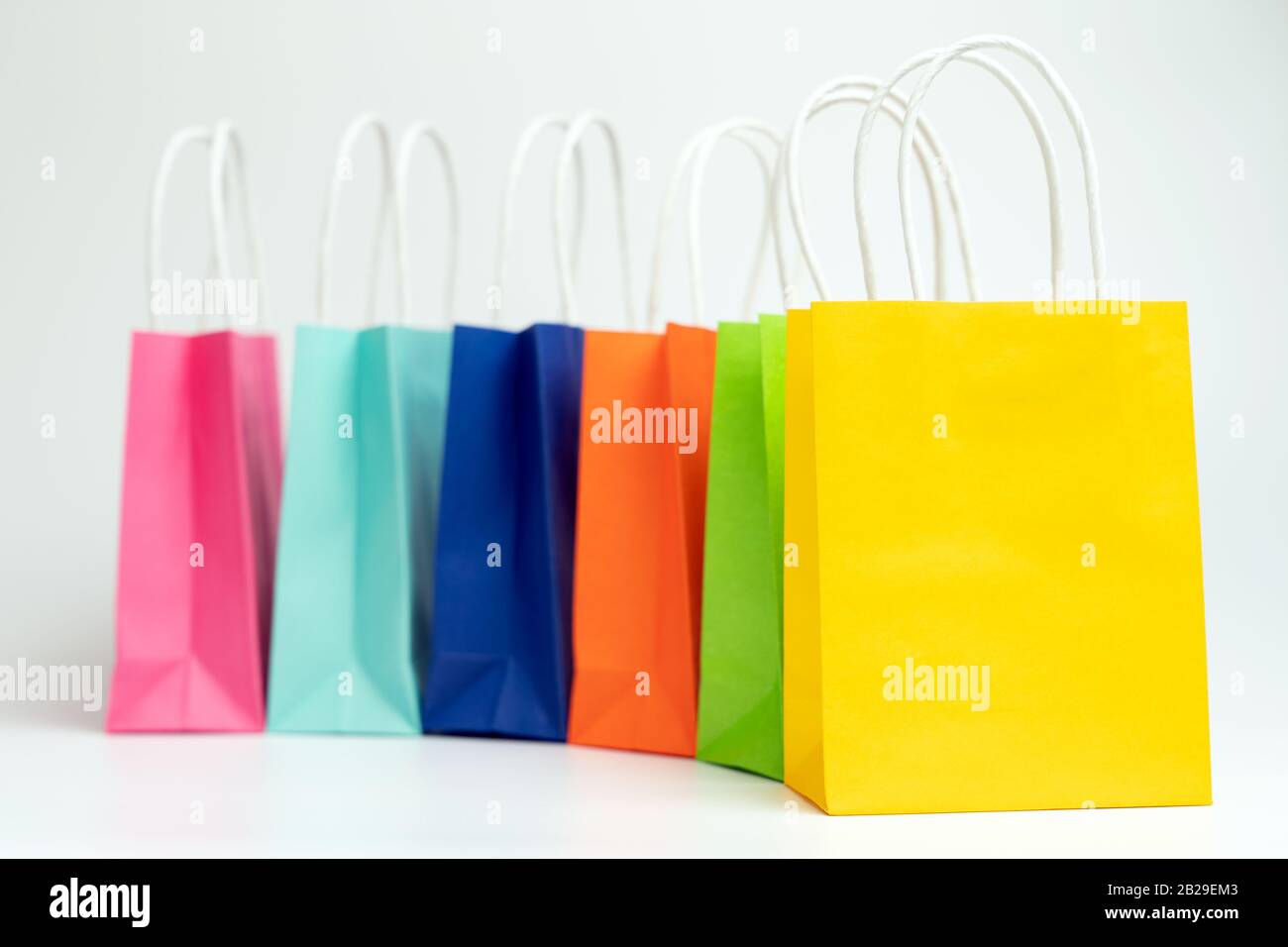 Colorful shopping bags standing in a row Stock Photo - Alamy