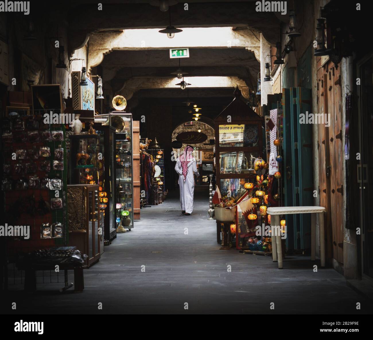 Man in traditional qatari robe wandering through Souq Waqif in Doha ...