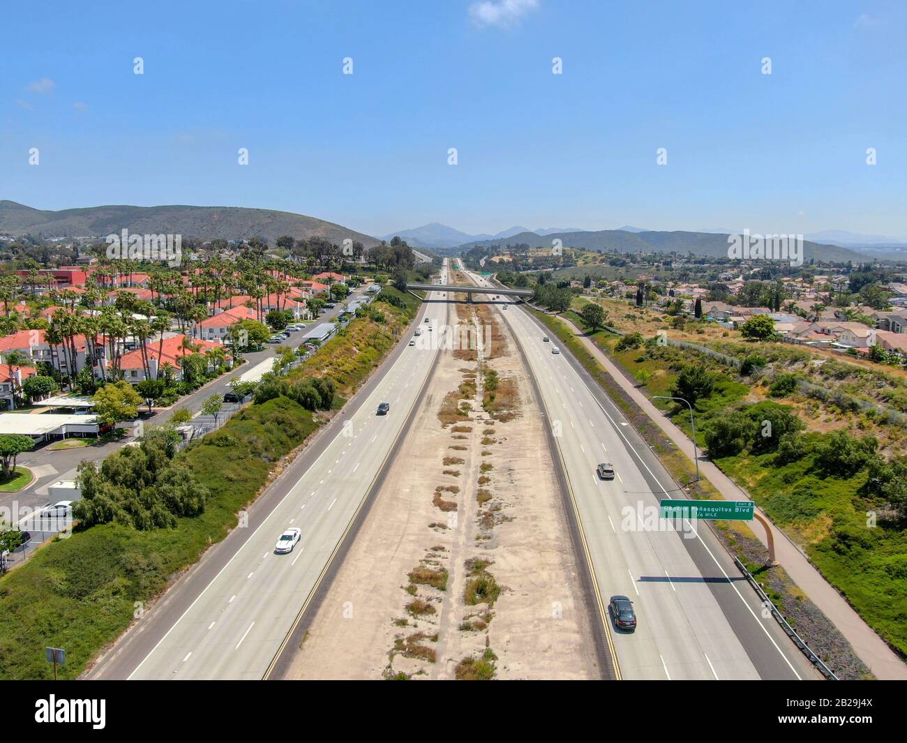 Aerial view of highway surrounded by villa in suburb. Intersection city ...