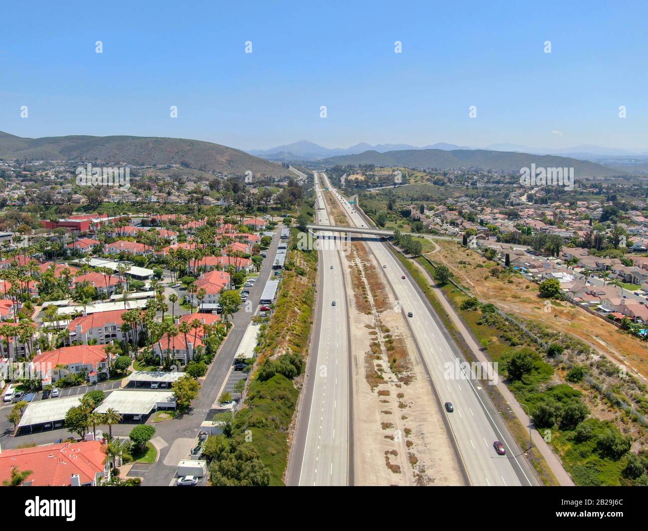 Aerial view of highway surrounded by villa in suburb. Intersection city ...