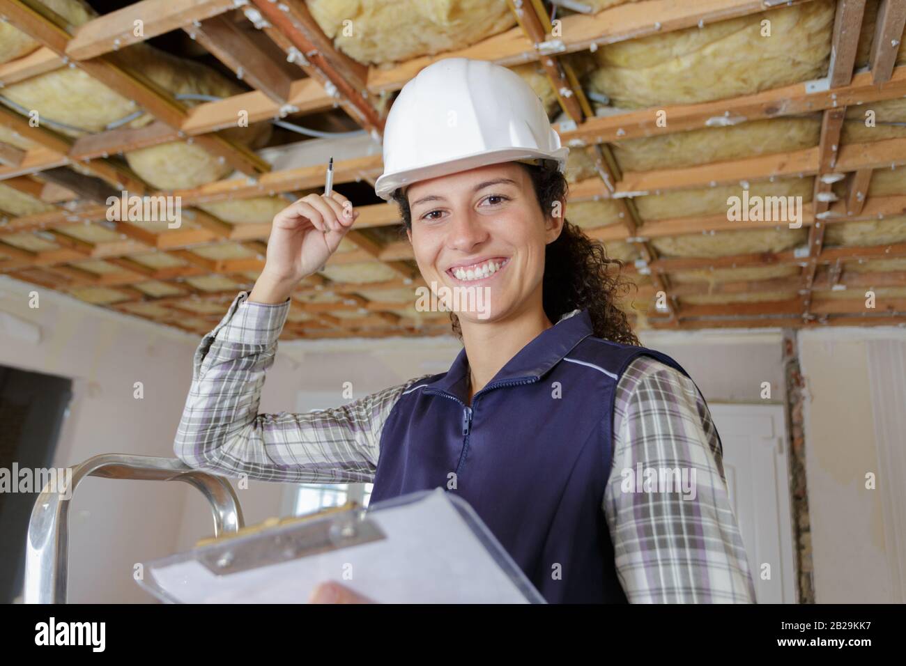 happy female builder with a clipboard Stock Photo - Alamy