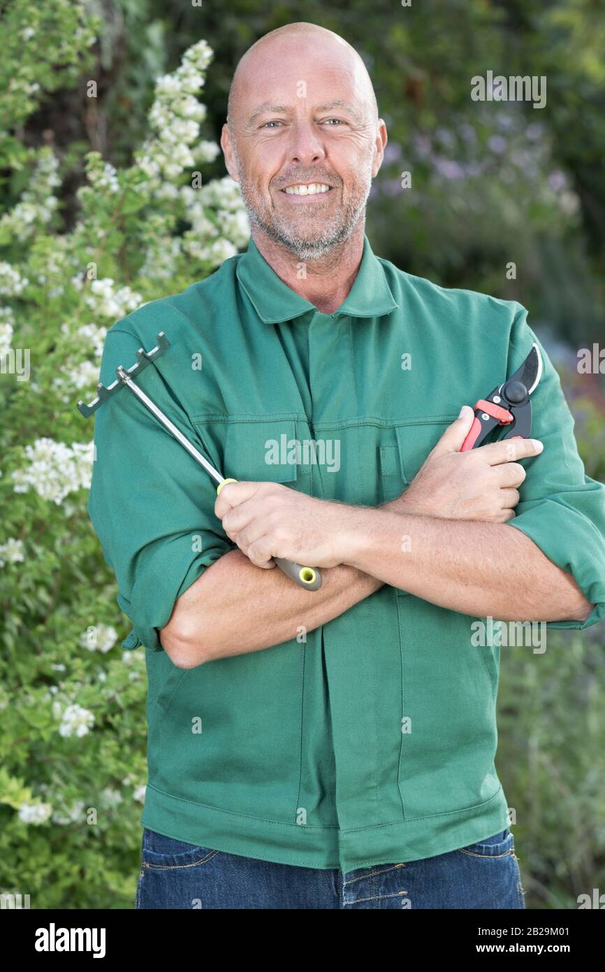gardener posing with rakes Stock Photo - Alamy