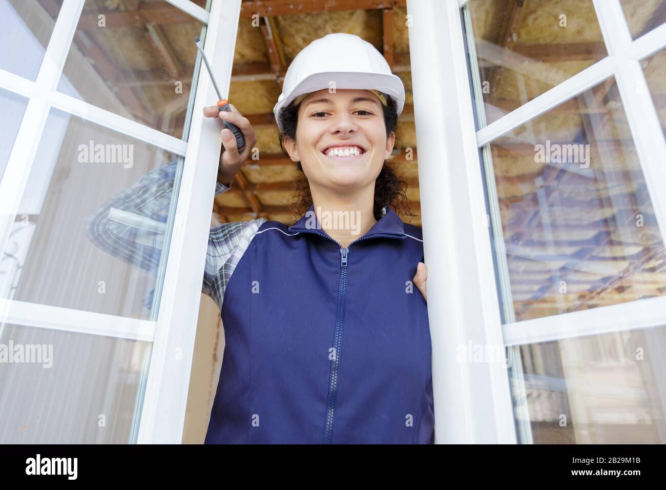 happy woman builder opening a window Stock Photo - Alamy