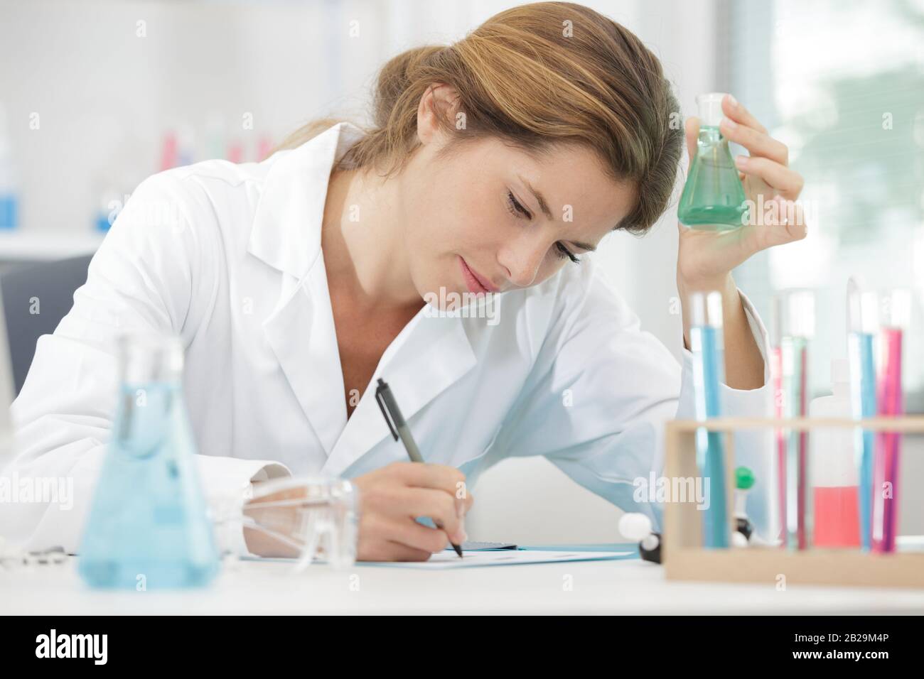 a female scientist taking notes Stock Photo - Alamy