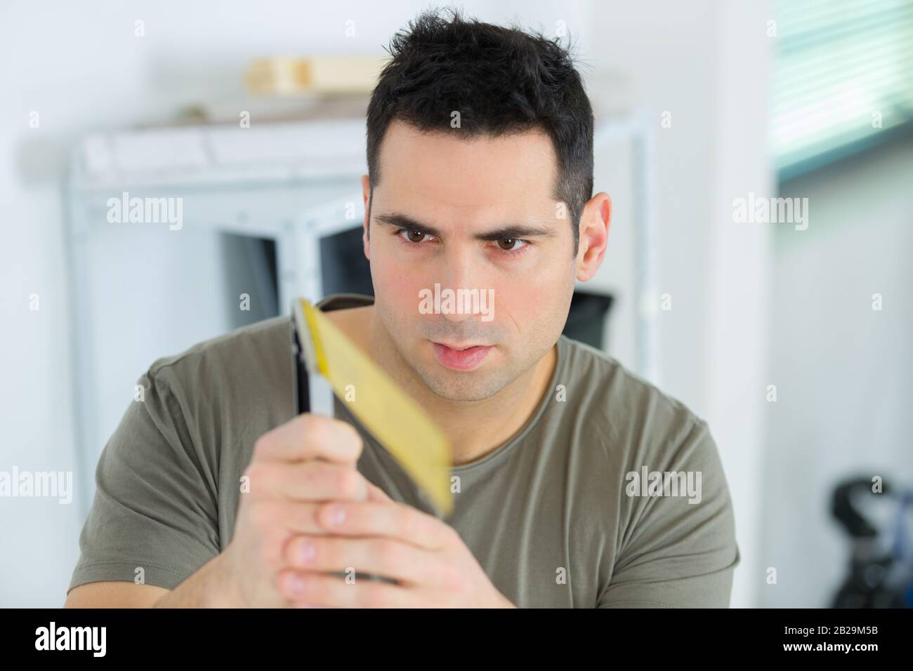man staring at object he is holding Stock Photo - Alamy