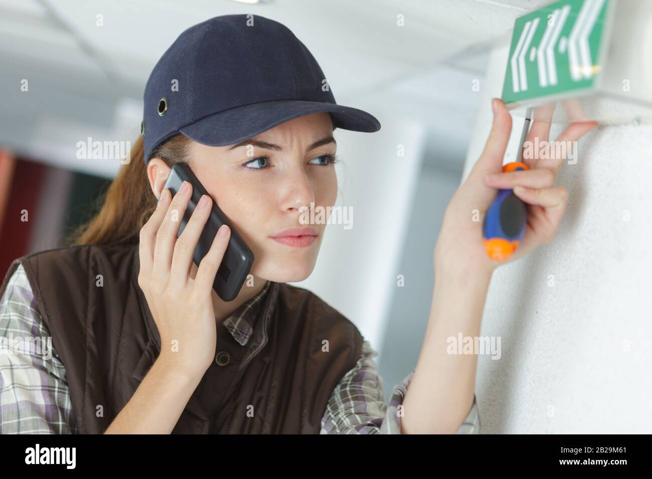 female technician using a smart phone emergency exit Stock Photo - Alamy