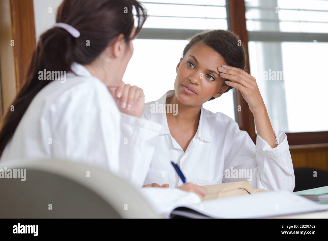 two beautiful female doctors are talking Stock Photo - Alamy