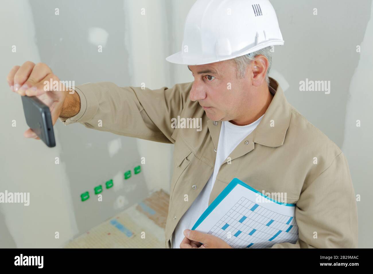 senior contractor using smartphone to photograph site Stock Photo - Alamy