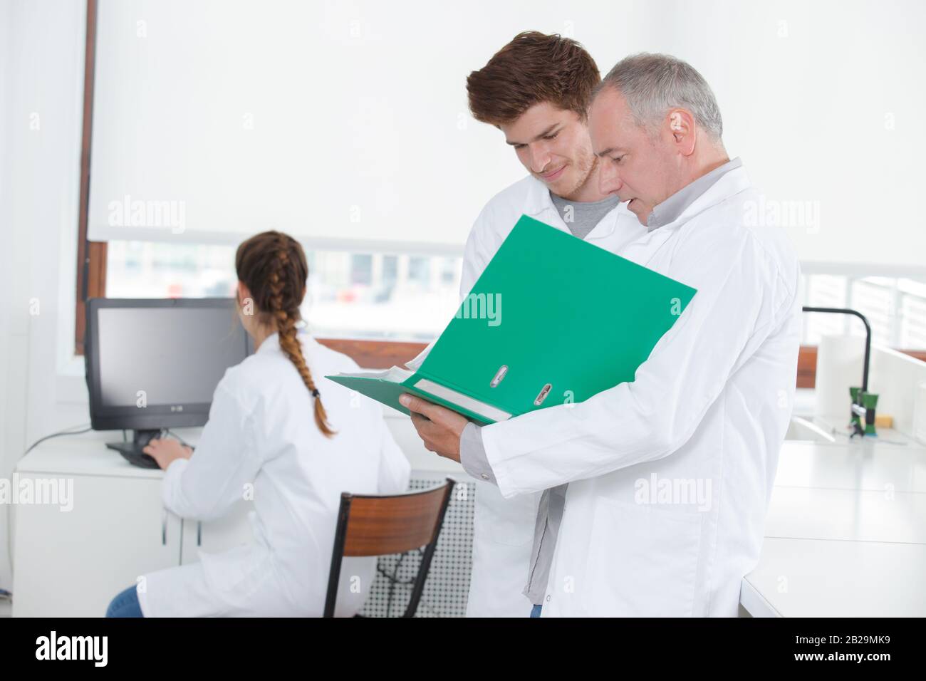 male teacher with teenage students experimenting at desk in lab Stock ...