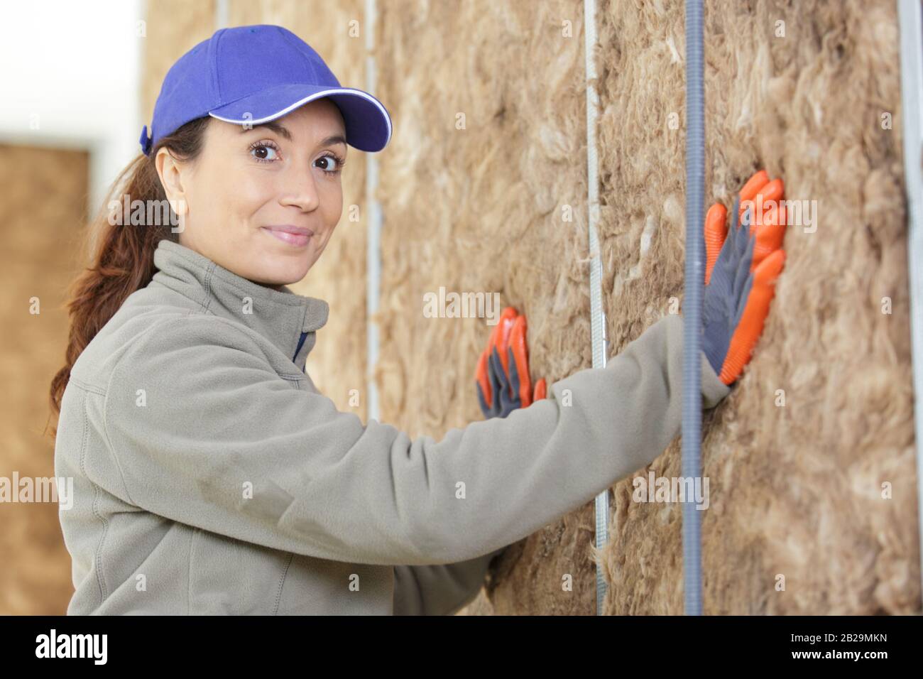 female worker at a indoors wall insulation works Stock Photo - Alamy