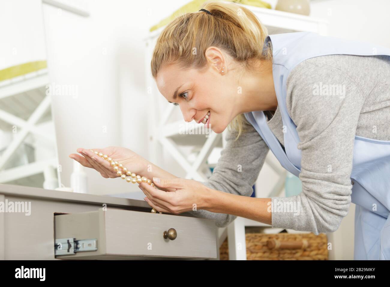 housekepeer stealing pearl necklace Stock Photo - Alamy
