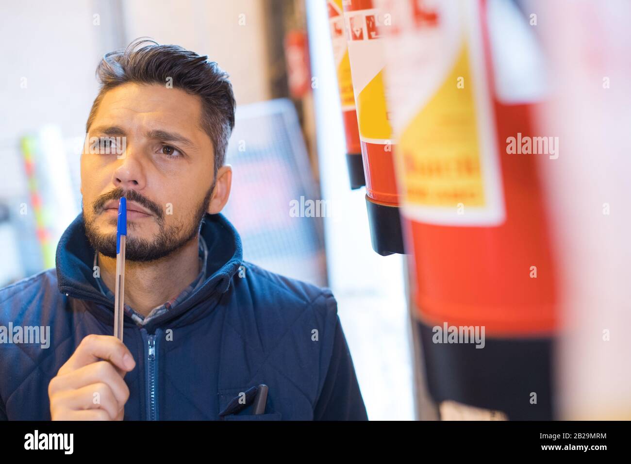 man thinking about fire extinguisher Stock Photo - Alamy