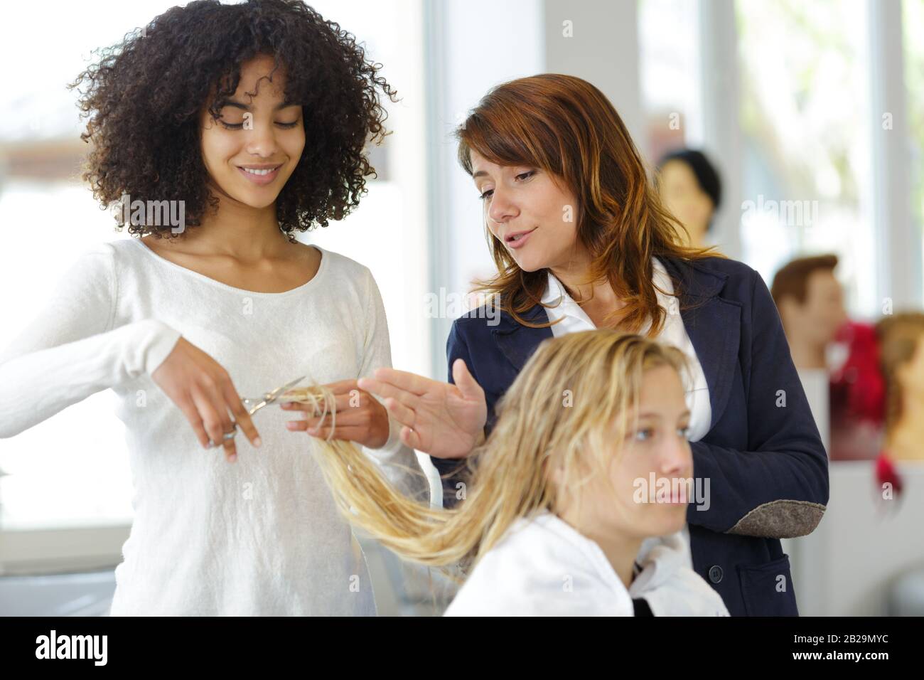 trainee hairdresser cutting clients hair Stock Photo - Alamy