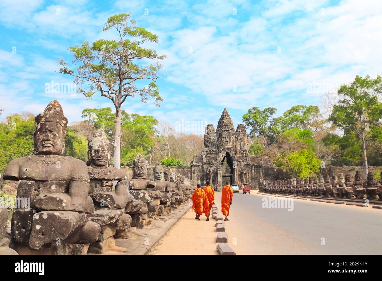 Three buddhist monks and stone statue of giants guardians in Front Gate ...
