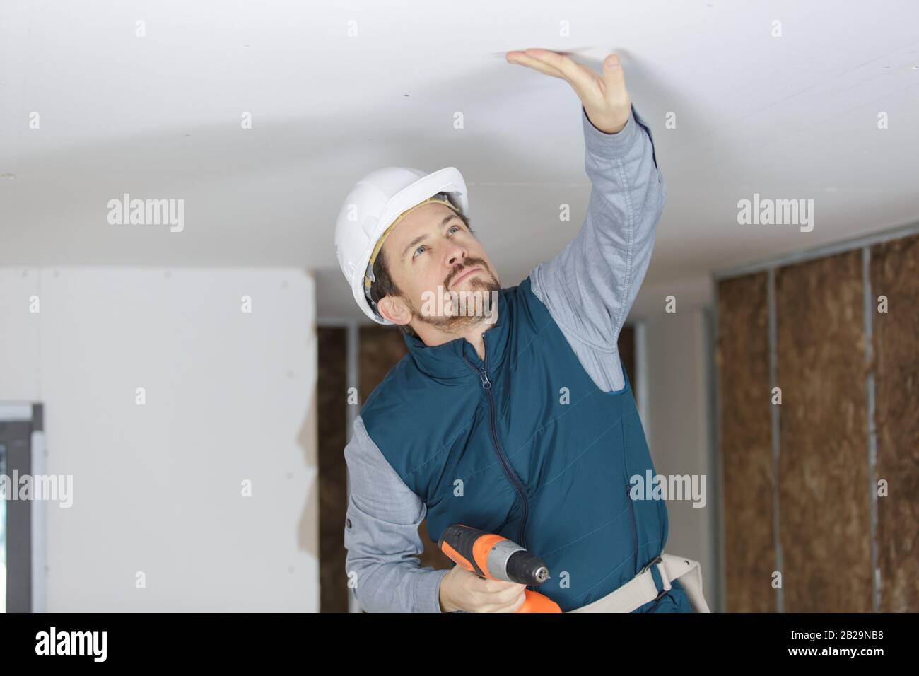 house renovation worker checking the alignment of a ceiling Stock Photo ...