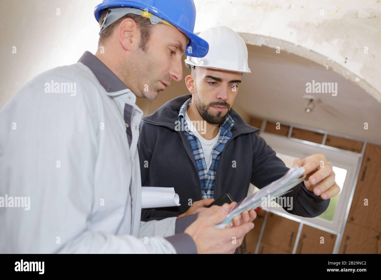 builders with clipboard and electrical panel indoors Stock Photo - Alamy