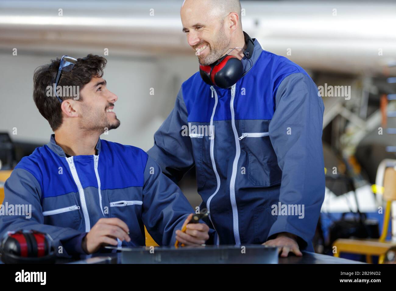 two happy aircraft mechanics talking Stock Photo - Alamy