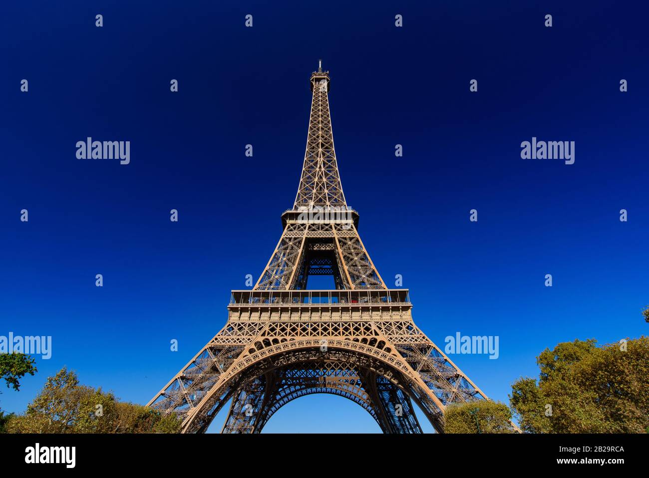 View of the Eiffel Tower in Paris on the Champs de Mars against a blue ...