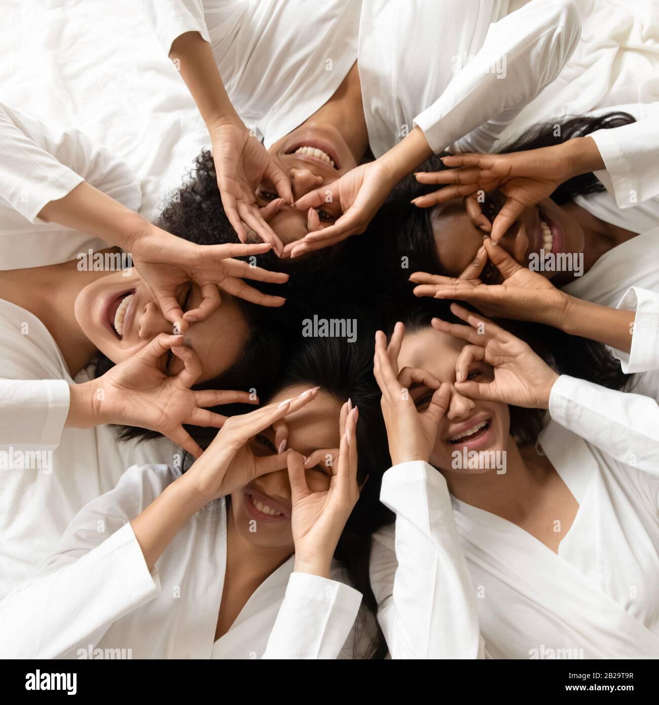 Top view funny diverse girls making binoculars, looking at camera Stock ...