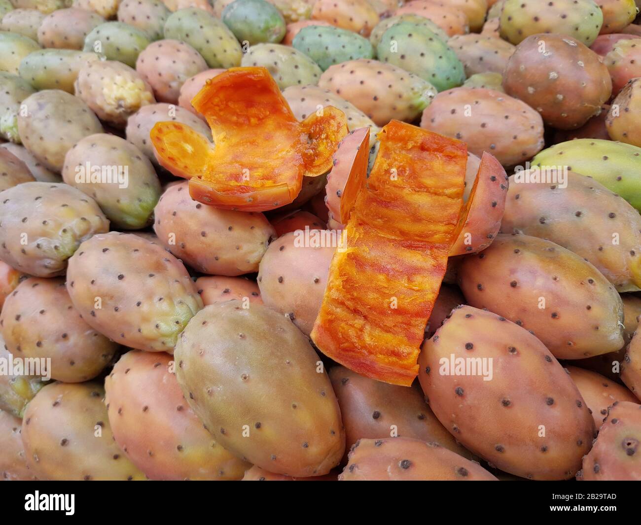 Cactus (prickly pear) fruit for sale. Remnants of peeled fruit in the ...