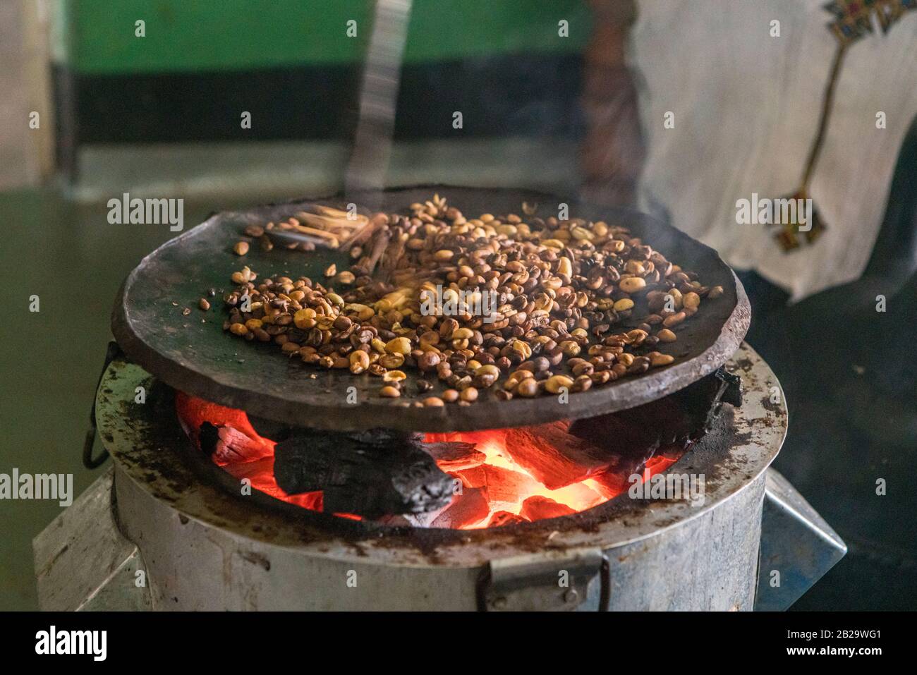 Roasting of coffee beans on a flat pan in a house in southern Ethiopia ...