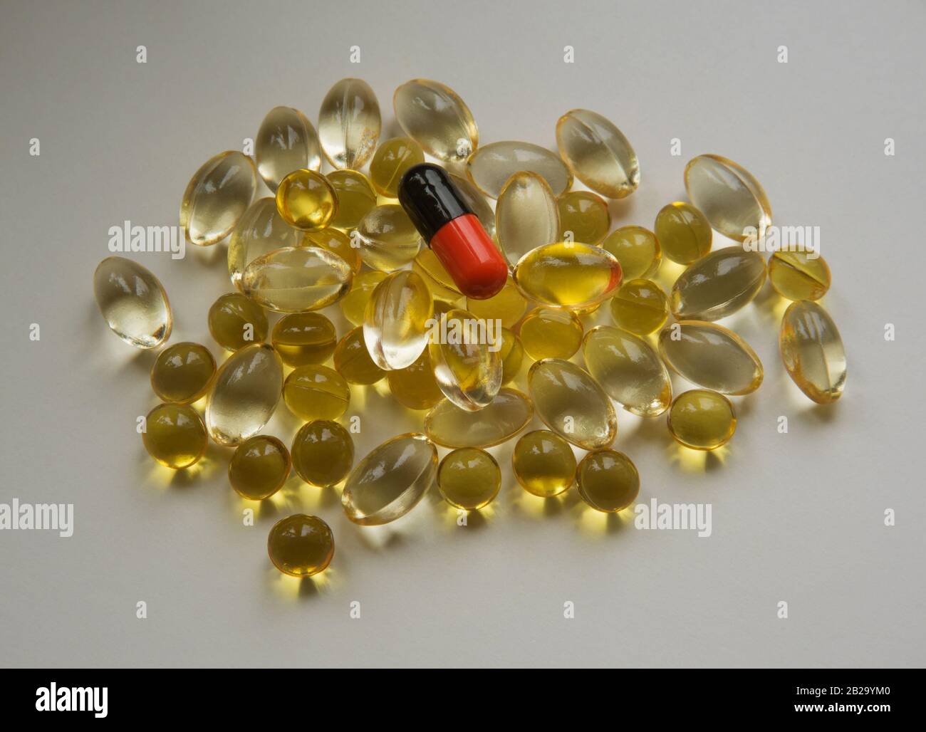 Red and black pill situated on transparent capsules arrangement Stock ...