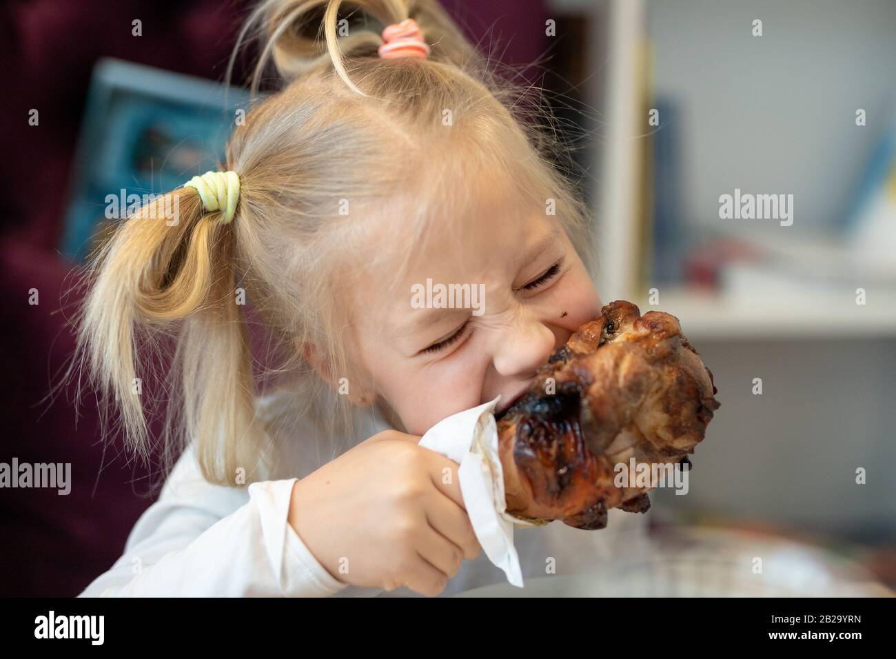 Cute adorable caucasian blond little girl portrait enjoy eating roasted ...