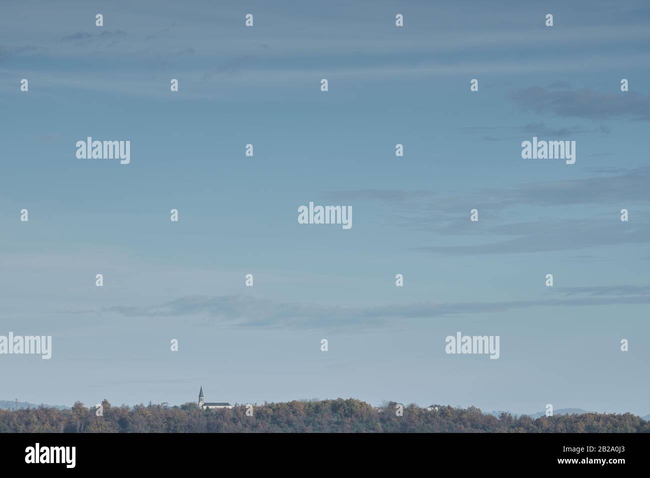 Soft and slightly contrasted image of distant church flanked by a lush ...