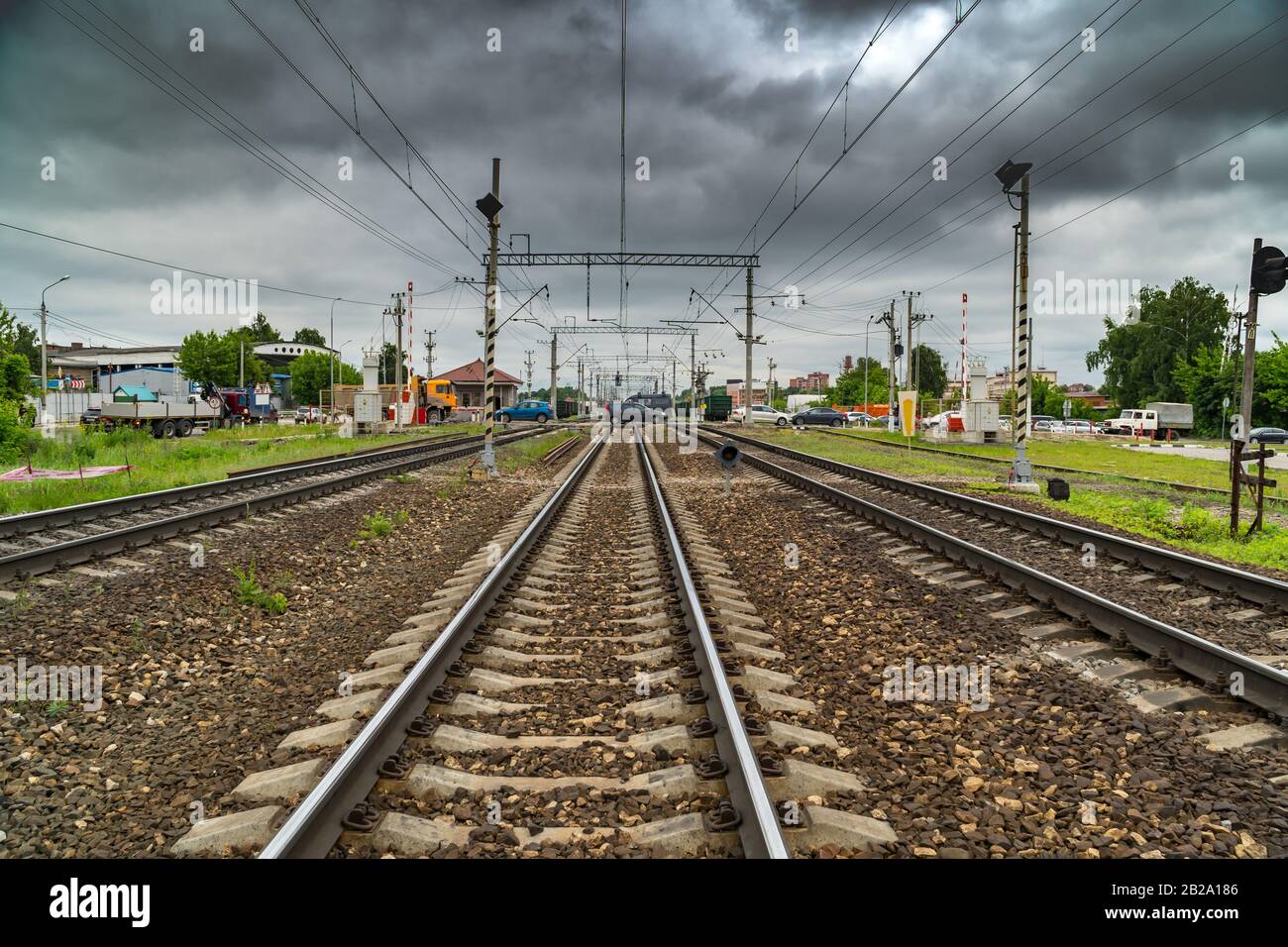 Cars cross the railroad tracks on the asphalted railroad crossing Stock ...