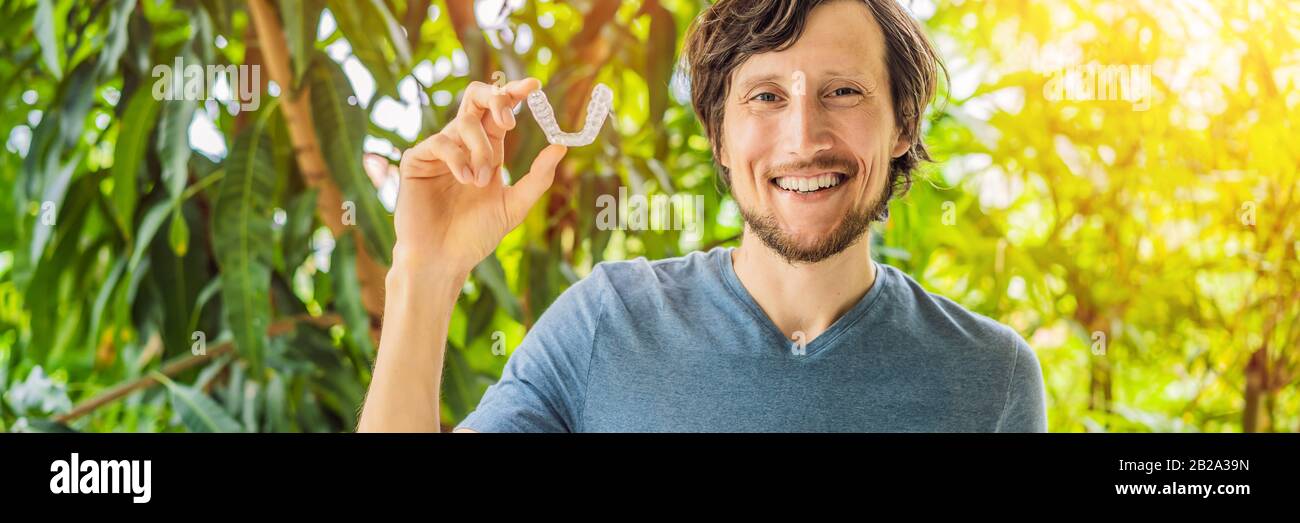 Man placing a bite plate in his mouth to protect his teeth at night ...