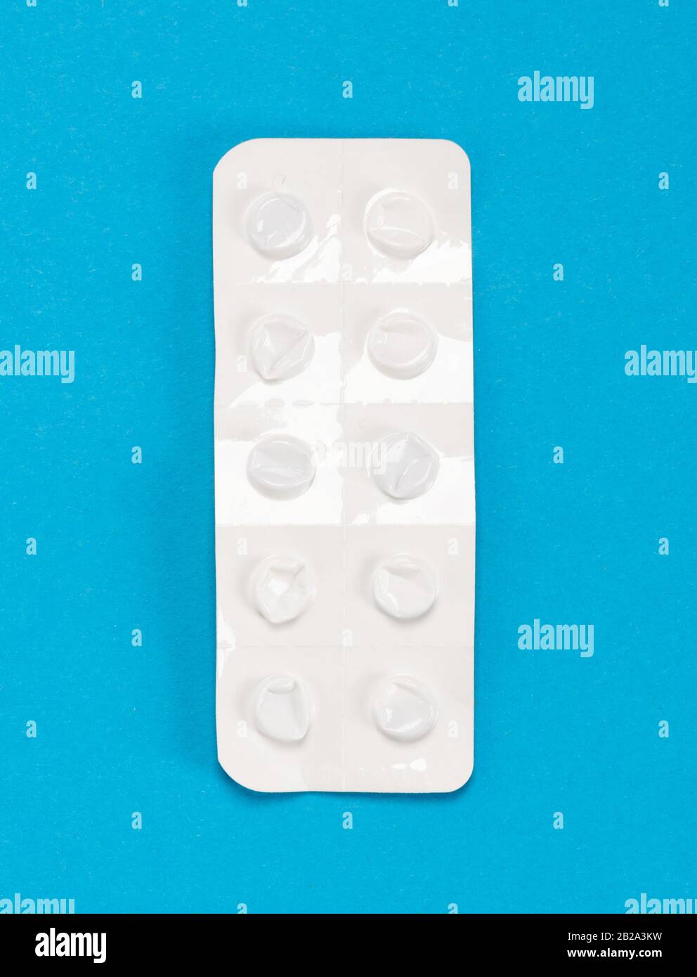 Pill strip isolated on a blue background Stock Photo - Alamy
