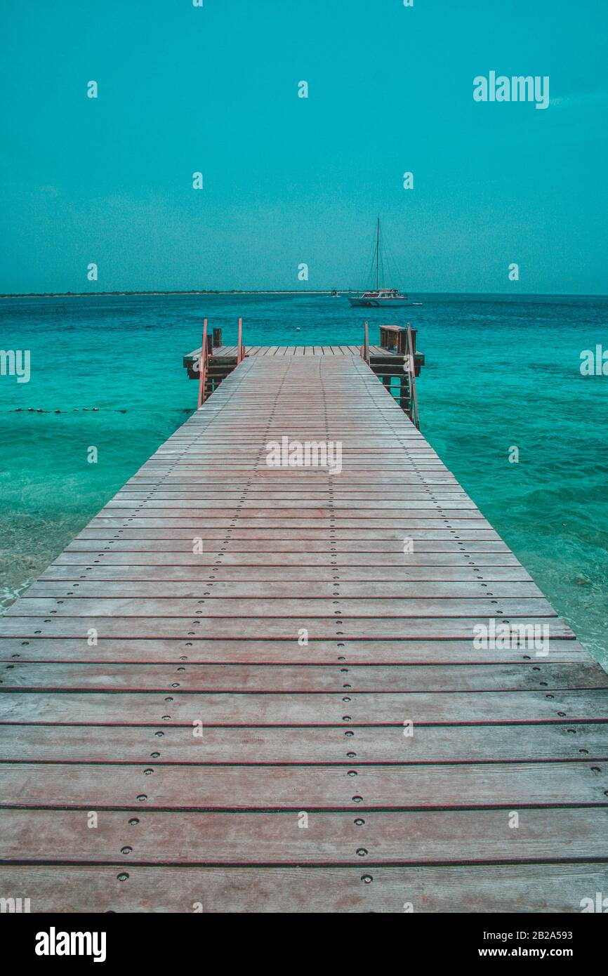 Wooden jetty into the blue ocean of Bonaire Stock Photo - Alamy