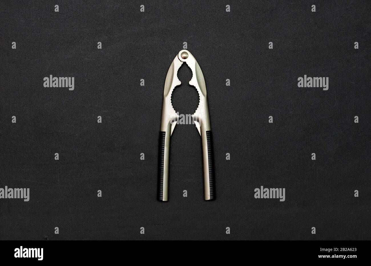 Tool for chopping nuts, nutcracker on a black background. Copy space ...
