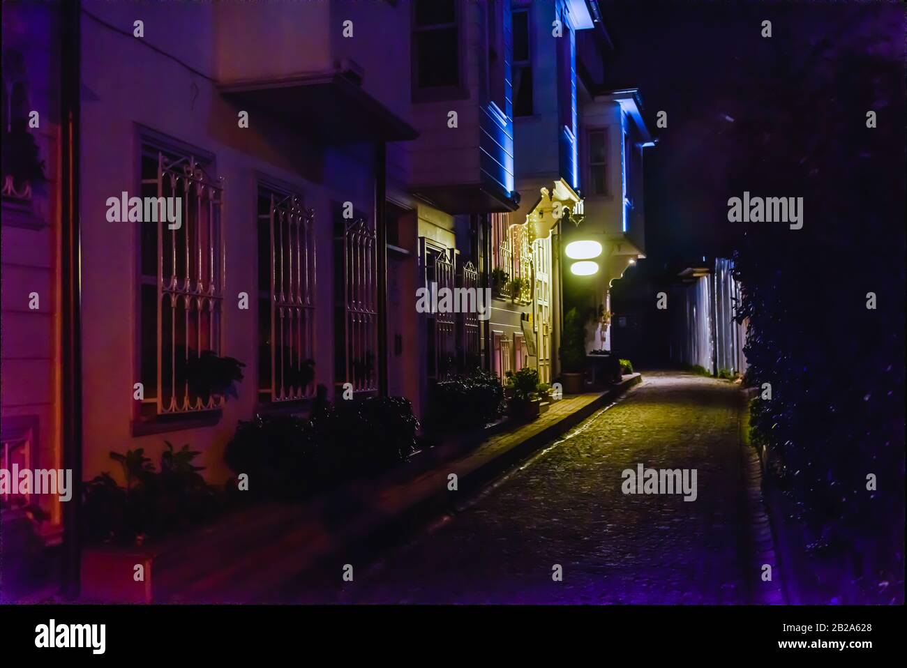 A narrow residential street with street lights and window bars ...