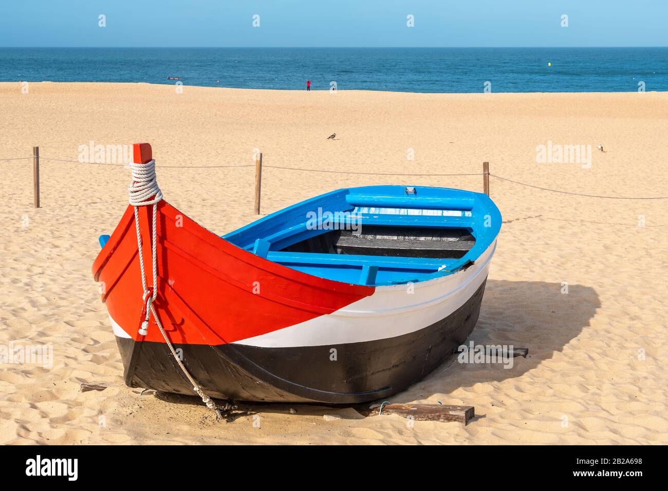 Traditional portuguese fishing boat on the ocean beach. Nazare ...