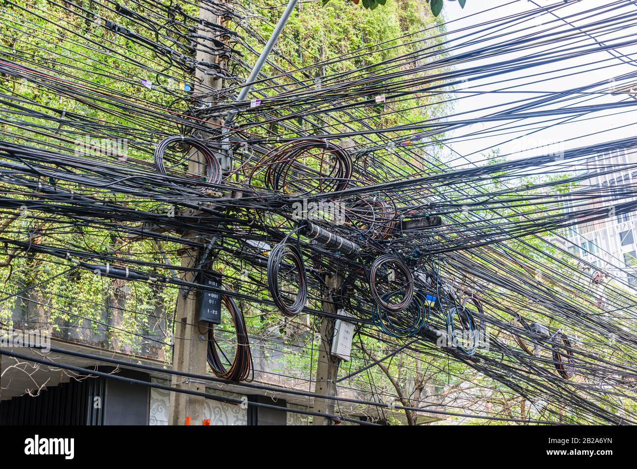 Messy and untidy electrical cables hanging from an electricity pole in ...