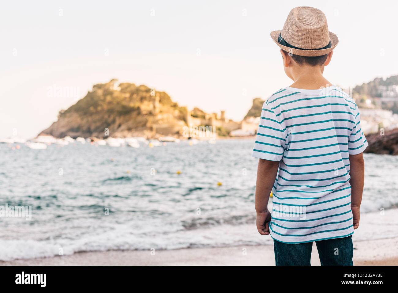 Little kid with hat looking the sea on the beach Stock Photo - Alamy