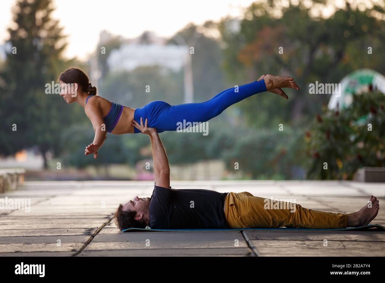 Young sport couple doing acroyoga base bird pose on hands Stock Photo ...