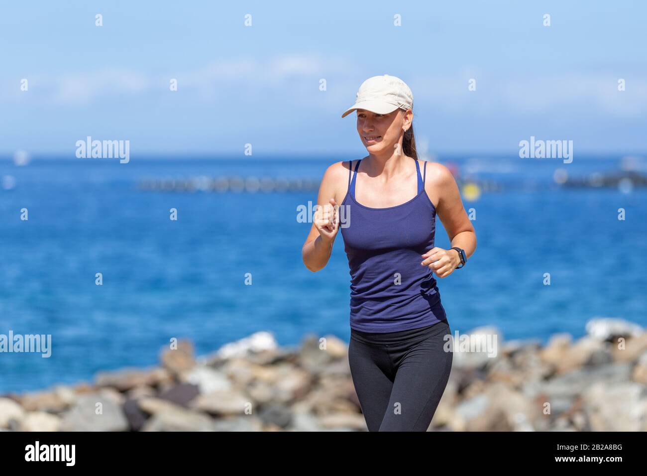 Young slim female runner near the sea jogging in the morning. Healthy ...