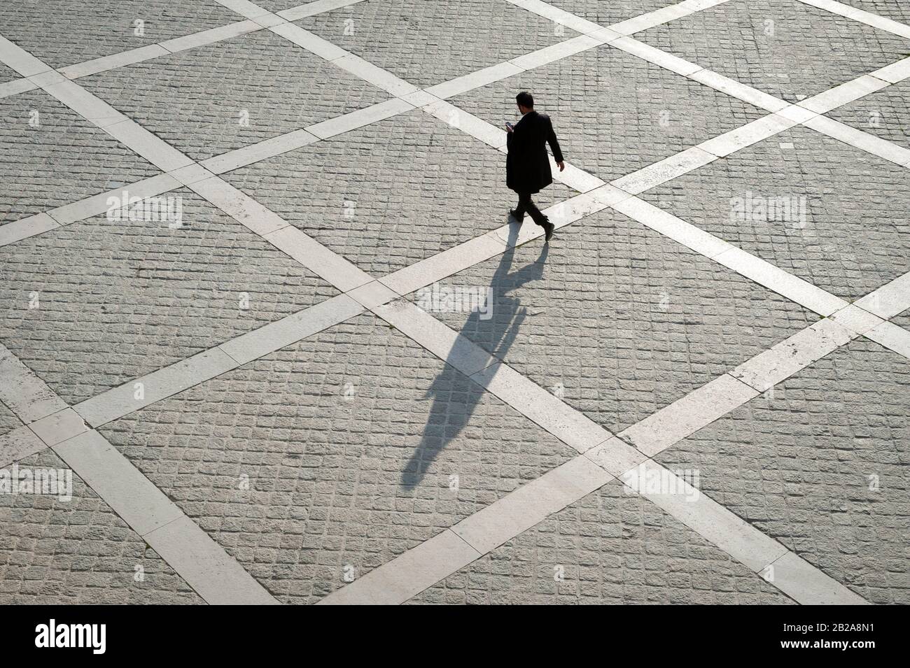 Overhead view of unrecognizable pedestrian casting shadow on the ...